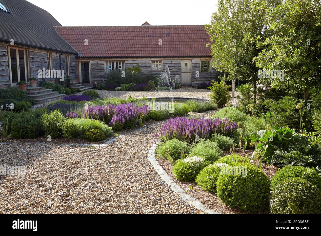 Courtyard with wood clad buildings, gravel path and planting. Manor ...