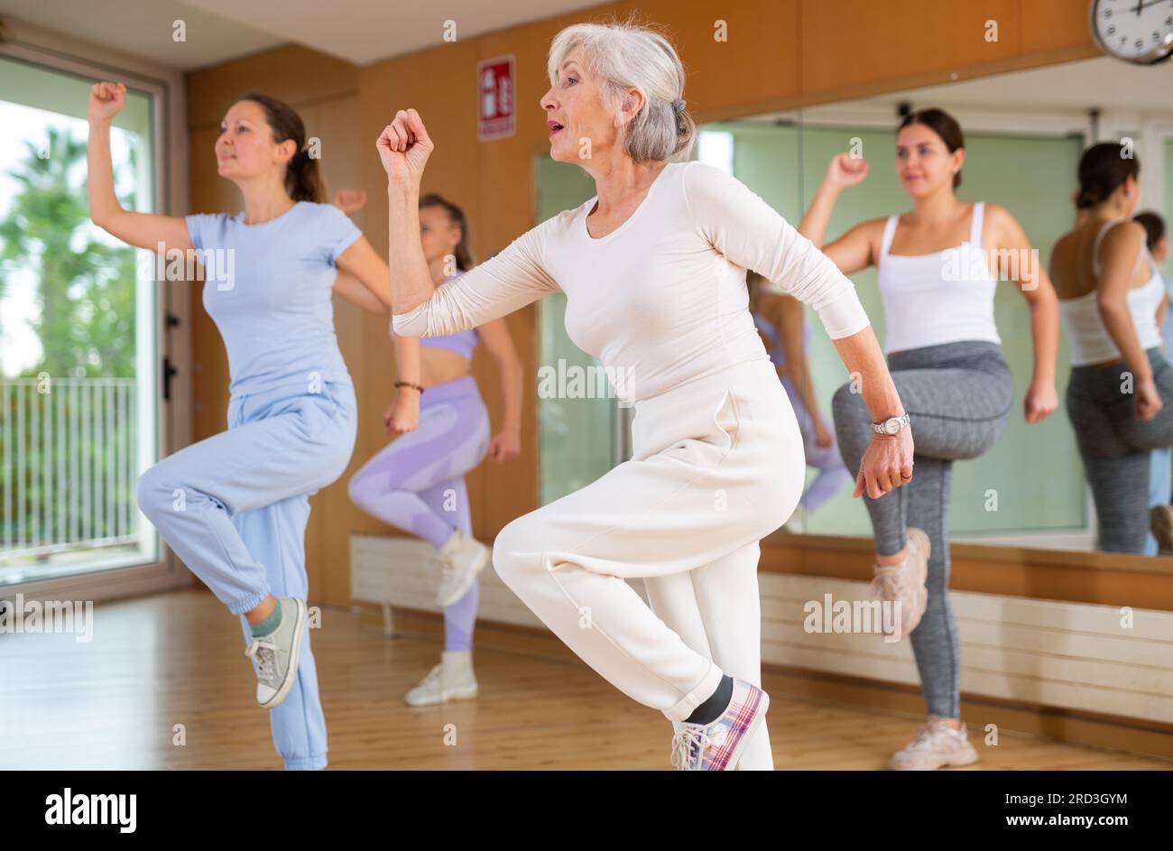 Dynamic elderly woman practicing aerobic dance in training hall Stock ...