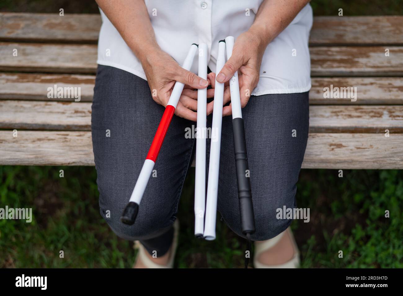 An elderly blind woman sits on a bench in the park. Close-up of female ...
