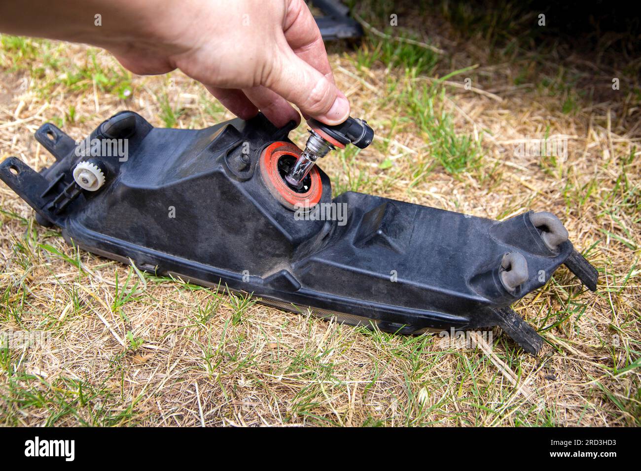 Replacing a burned out light bulb in a car headlight with an LED lamp ...