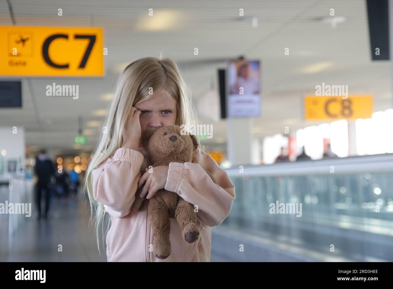 Child lost at the airport, can't find her parents. Upset little girl ...