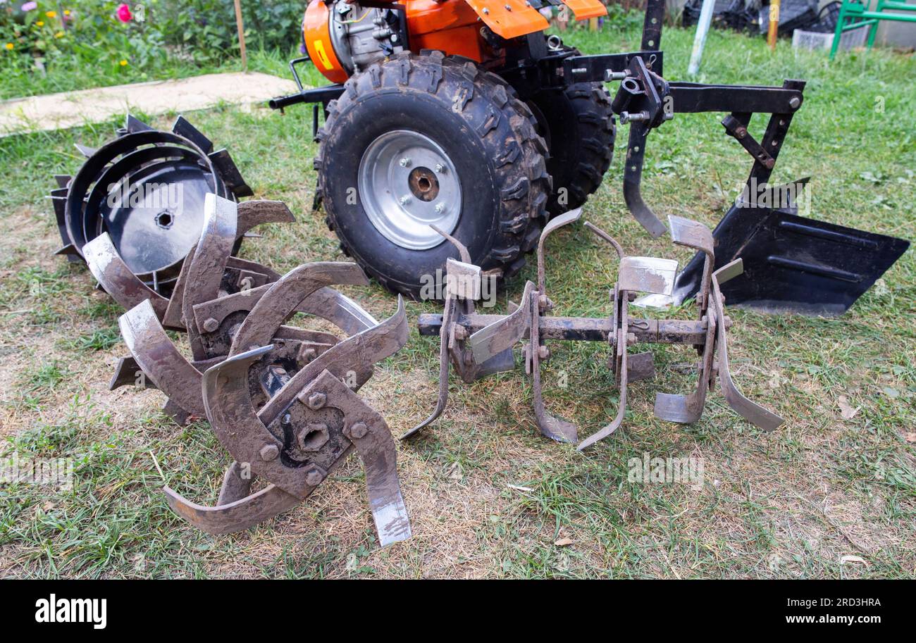 Agricultural walk-behind tractor with a set of attachments, hiller ...