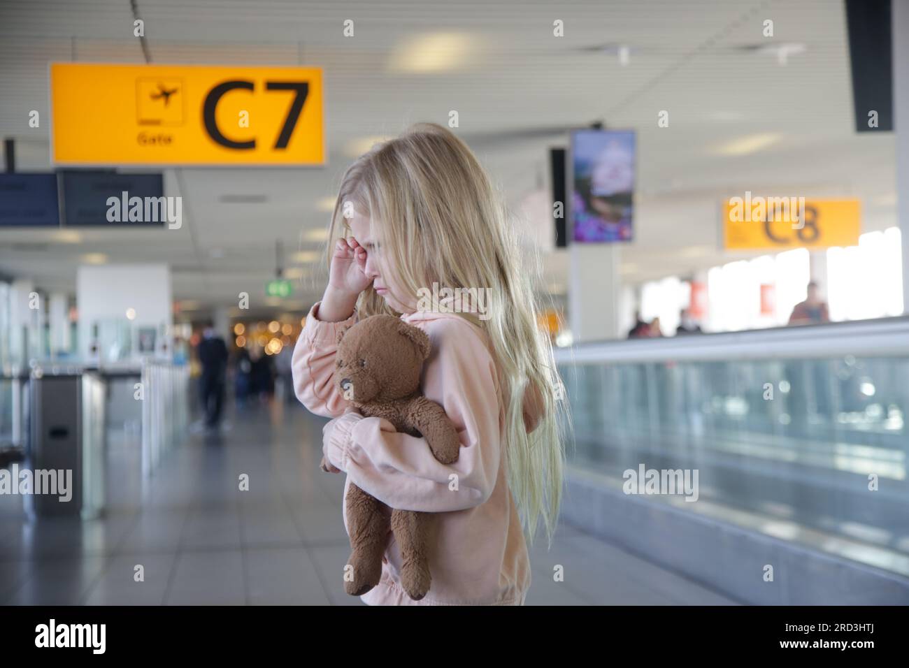 Child lost at the airport, can't find her parents. Upset little girl ...