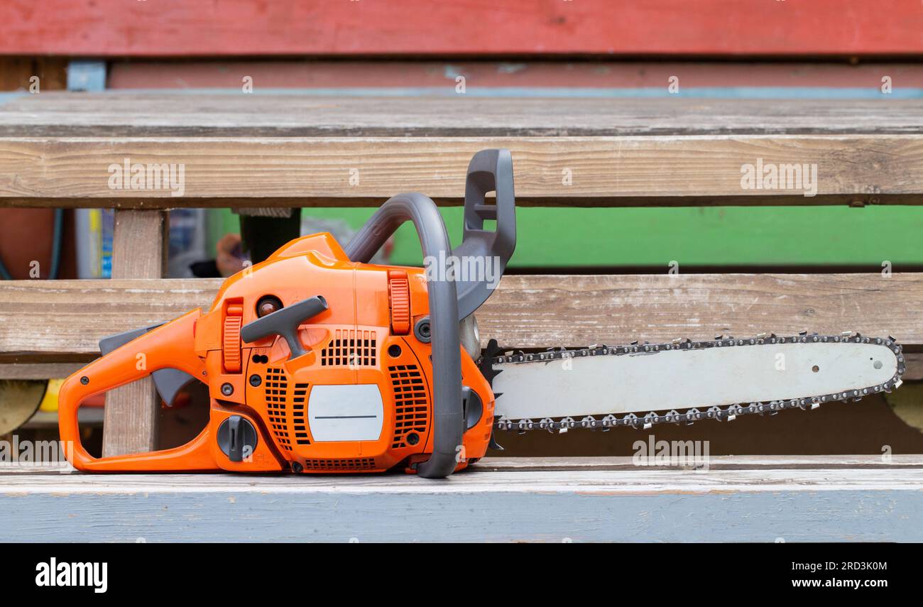 New modern chainsaw on a wood background. The concept of purchases and ...