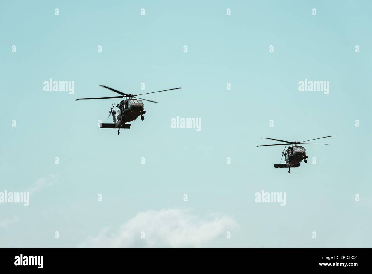 Two U.S. Army UH-60s fly over a grass assault zone during Special ...