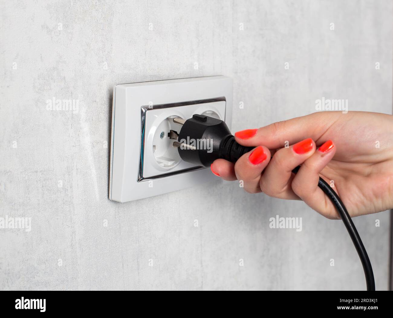 The girl removes the electrical plug from the socket and breaks the ...