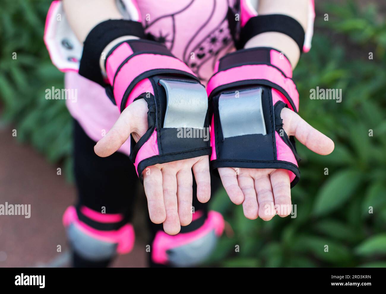 Hands of a girl in protective equipment against falls and injuries when ...