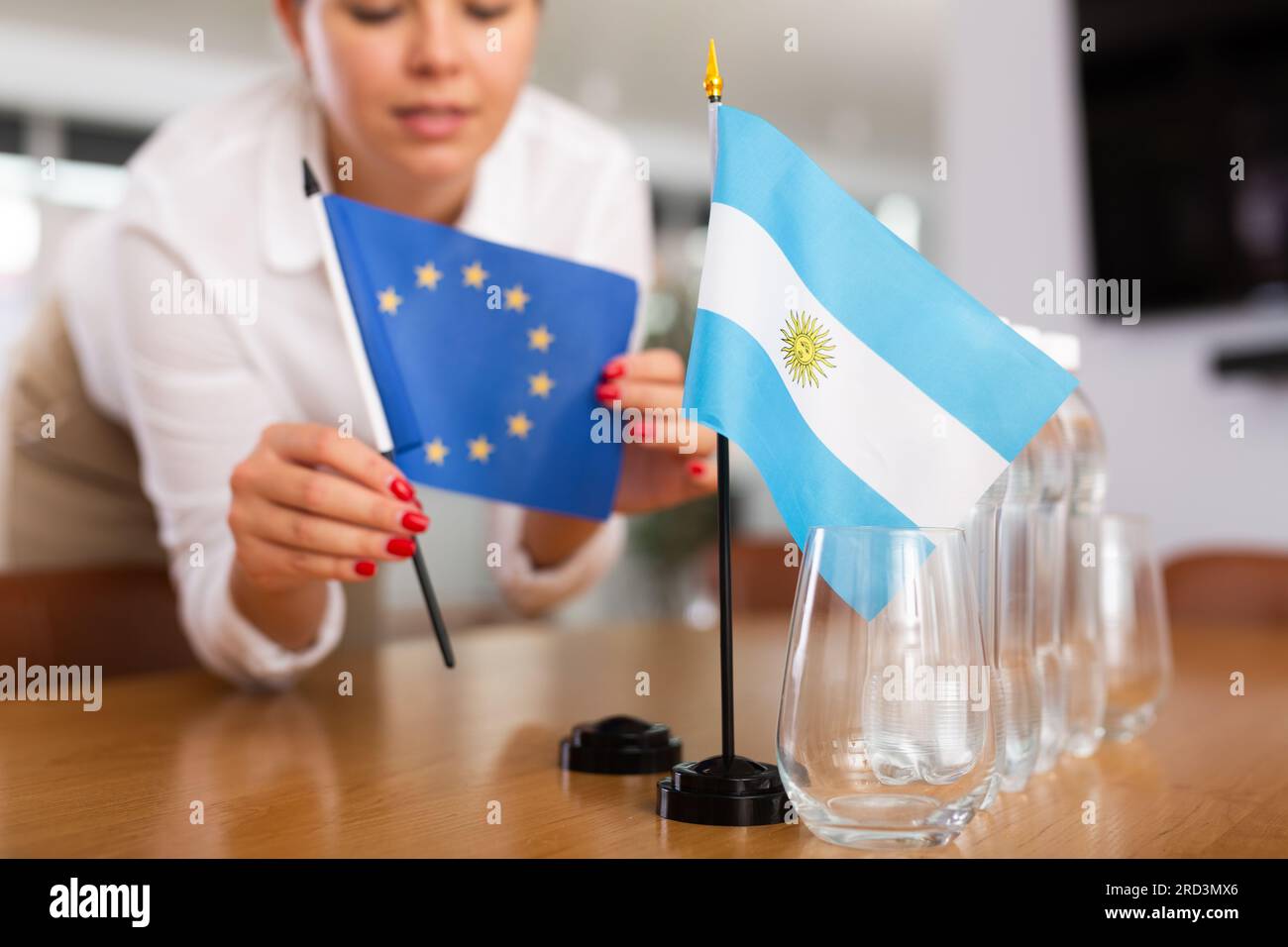 Unrecognizable girl sets midget flags of Argentina and EU before ...