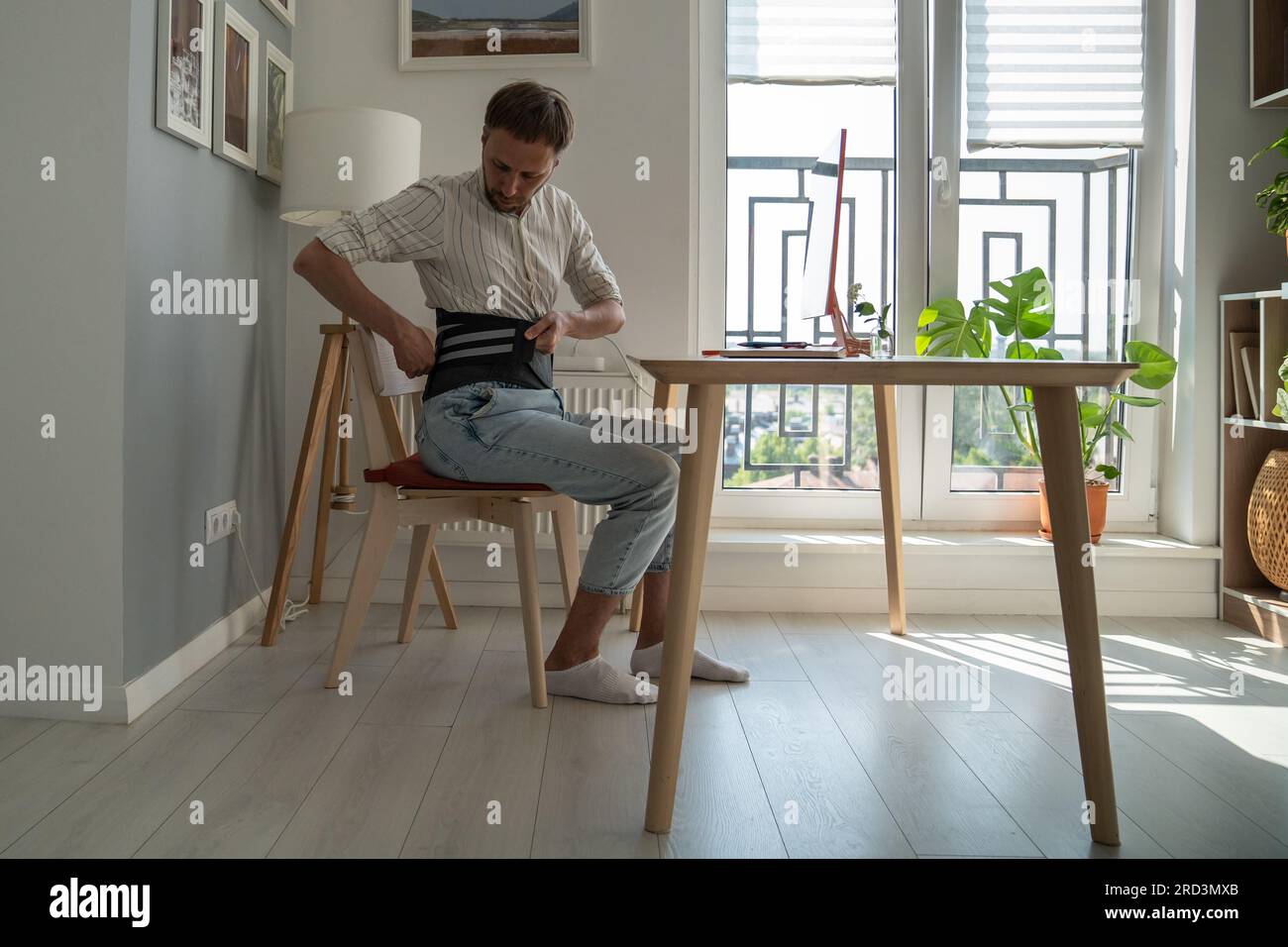 Man fixing belt corset before starting work to ease load on spine after ...