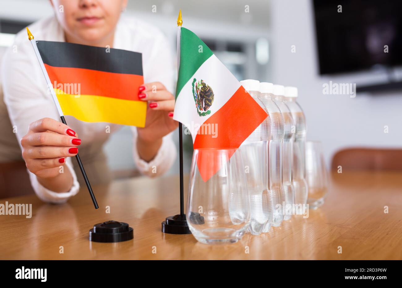 Unrecognizable girl sets midget flags of Mexico and Germany before ...