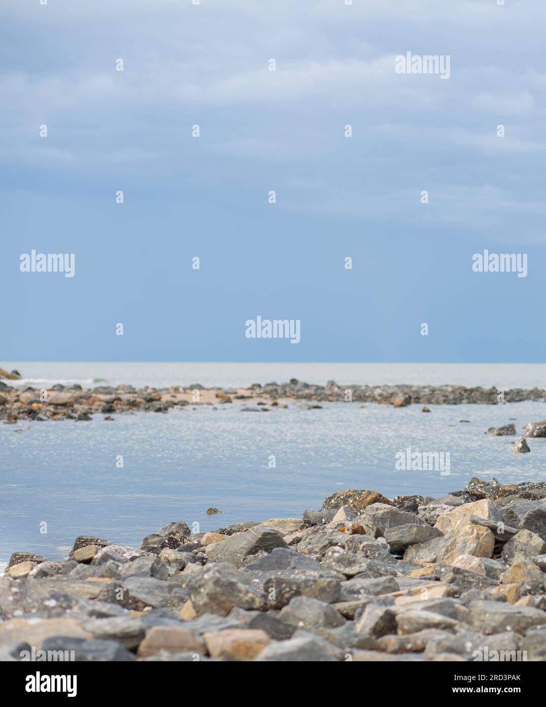 Lots of rocks by the sea, clear sky sea background Stock Photo - Alamy
