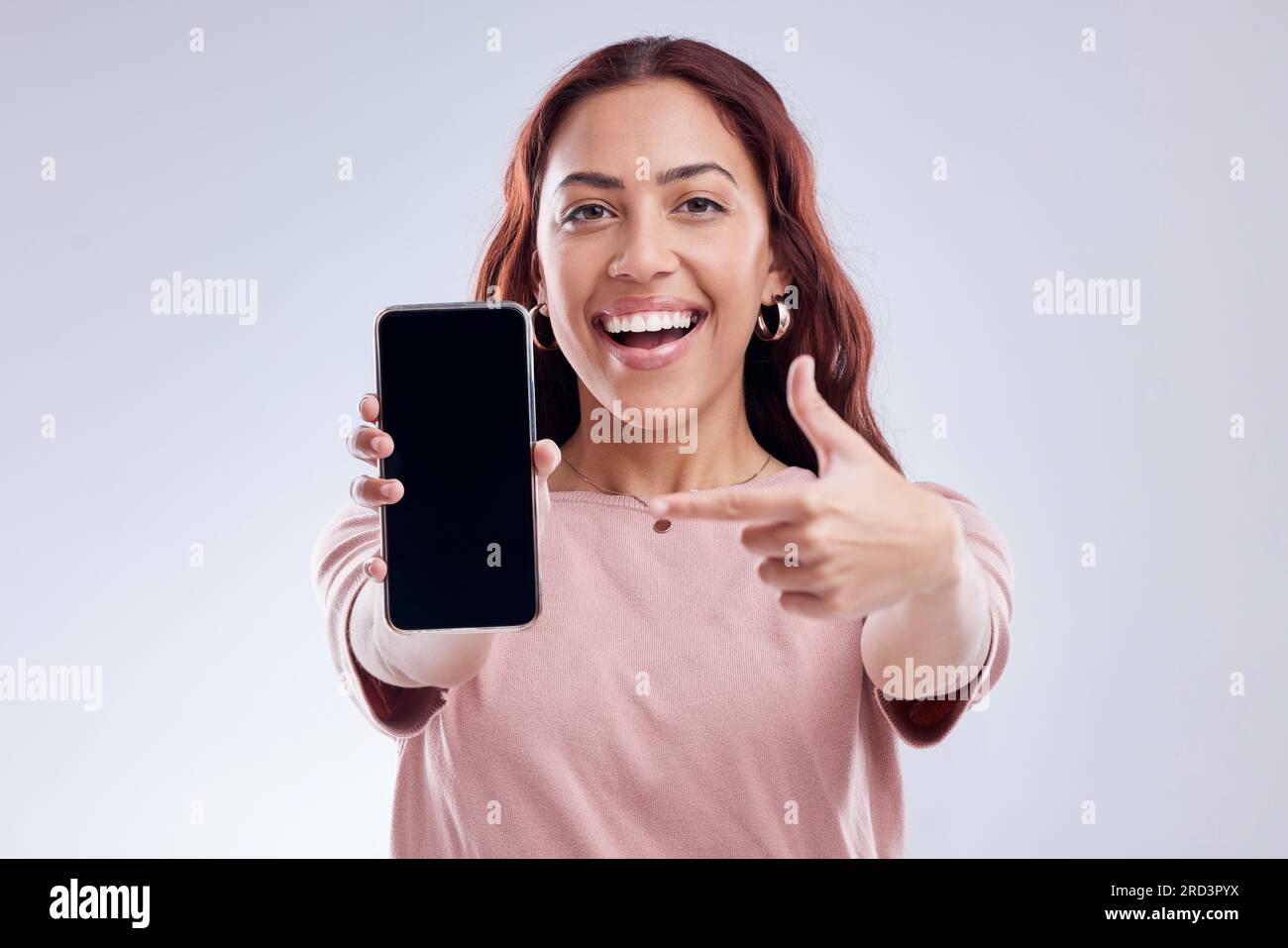 Happy woman is pointing at phone screen, mockup and marketing, mobile ...