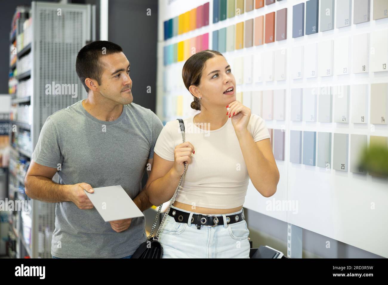 Near stand with samples paint, palette of colors of coating, couple ...