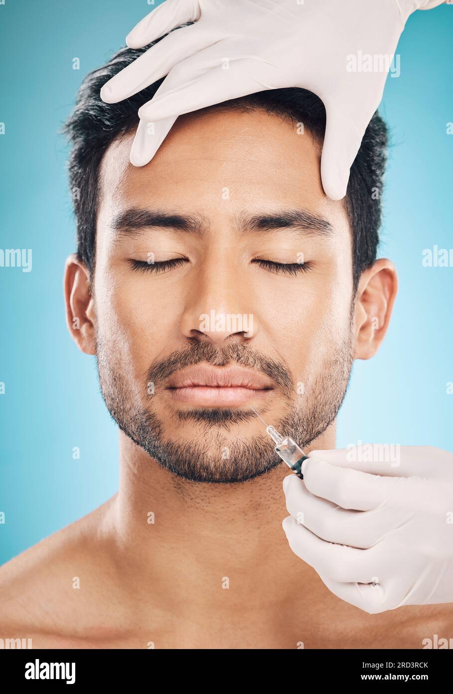 Face, hands and botox with a plastic surgery man in studio on a blue ...