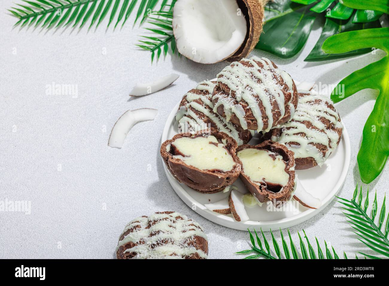 Profiteroles choux pastry buns with coconut cream served in tropical ...