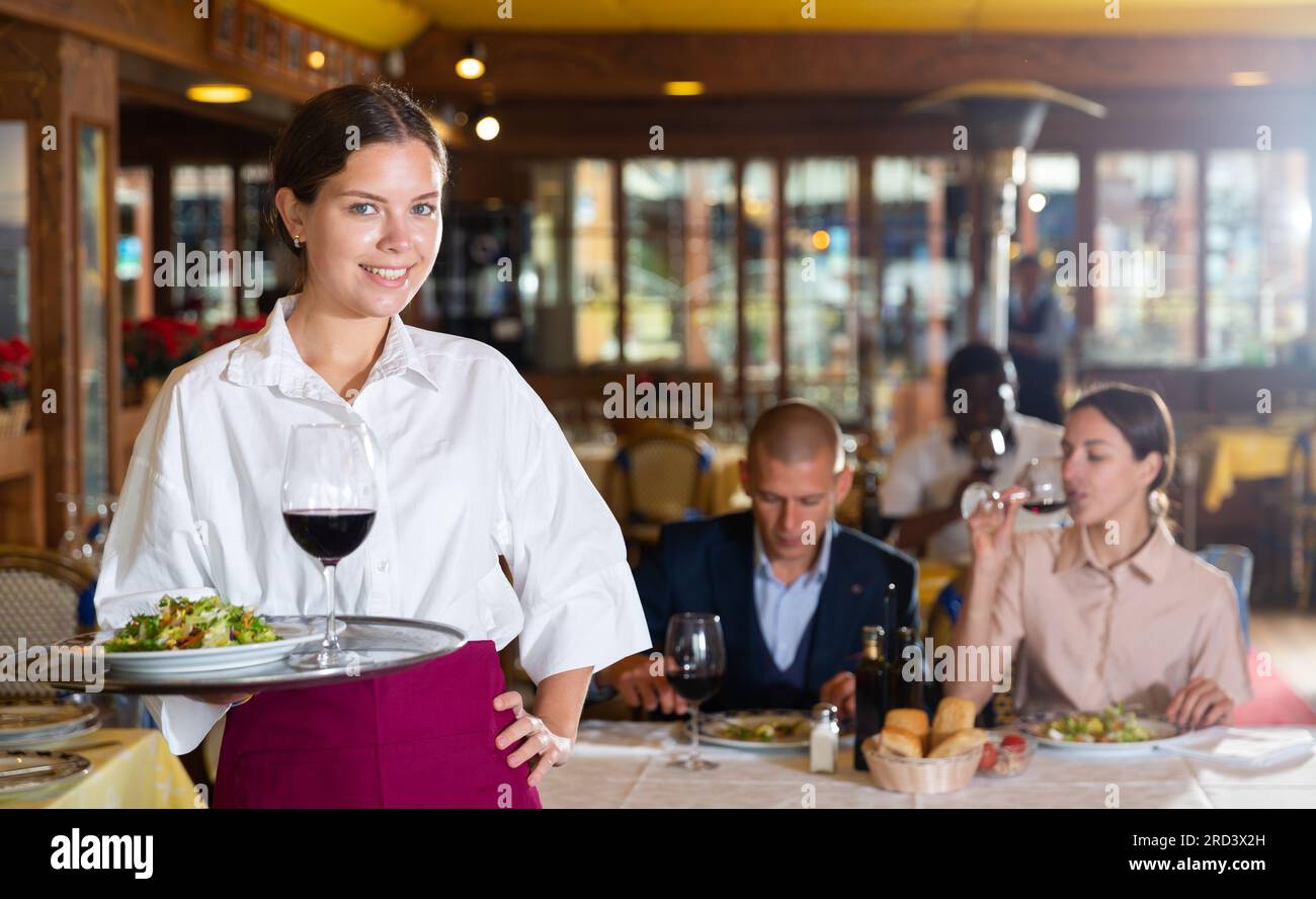Waiter standing with serving tray, recommending dishes in restaurant ...