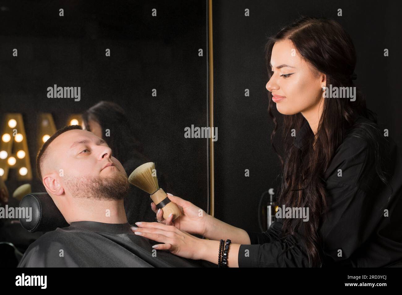A master hairdresser powders a man's beard with talcum powder in a ...