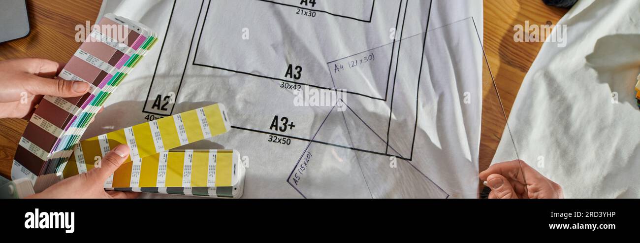 Top view of young multiethnic designers holding color swatches and ...