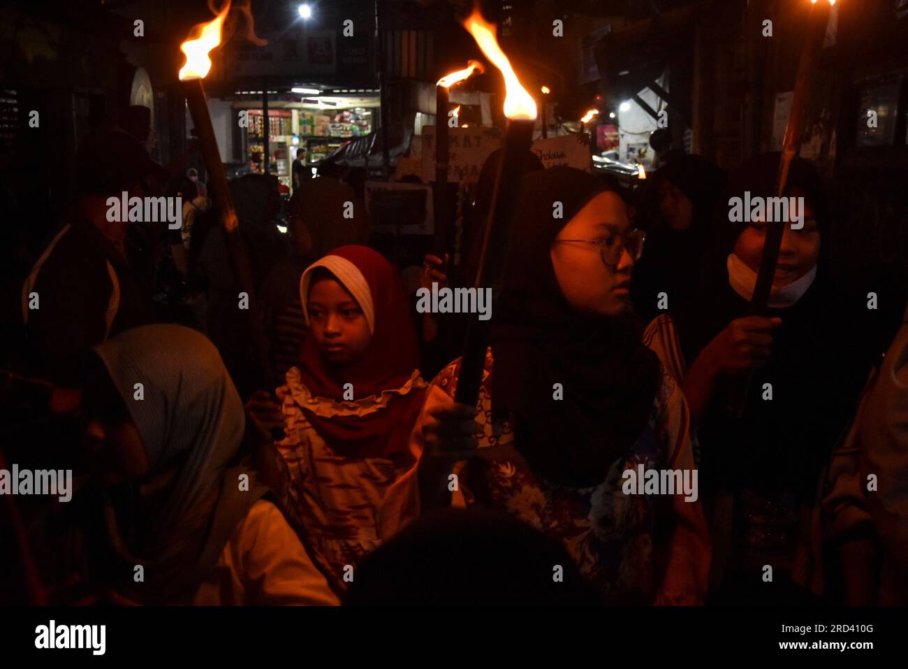 Bandung, West Java, Indonesia. July 18, 2023. Residents light torches while participating in a ...