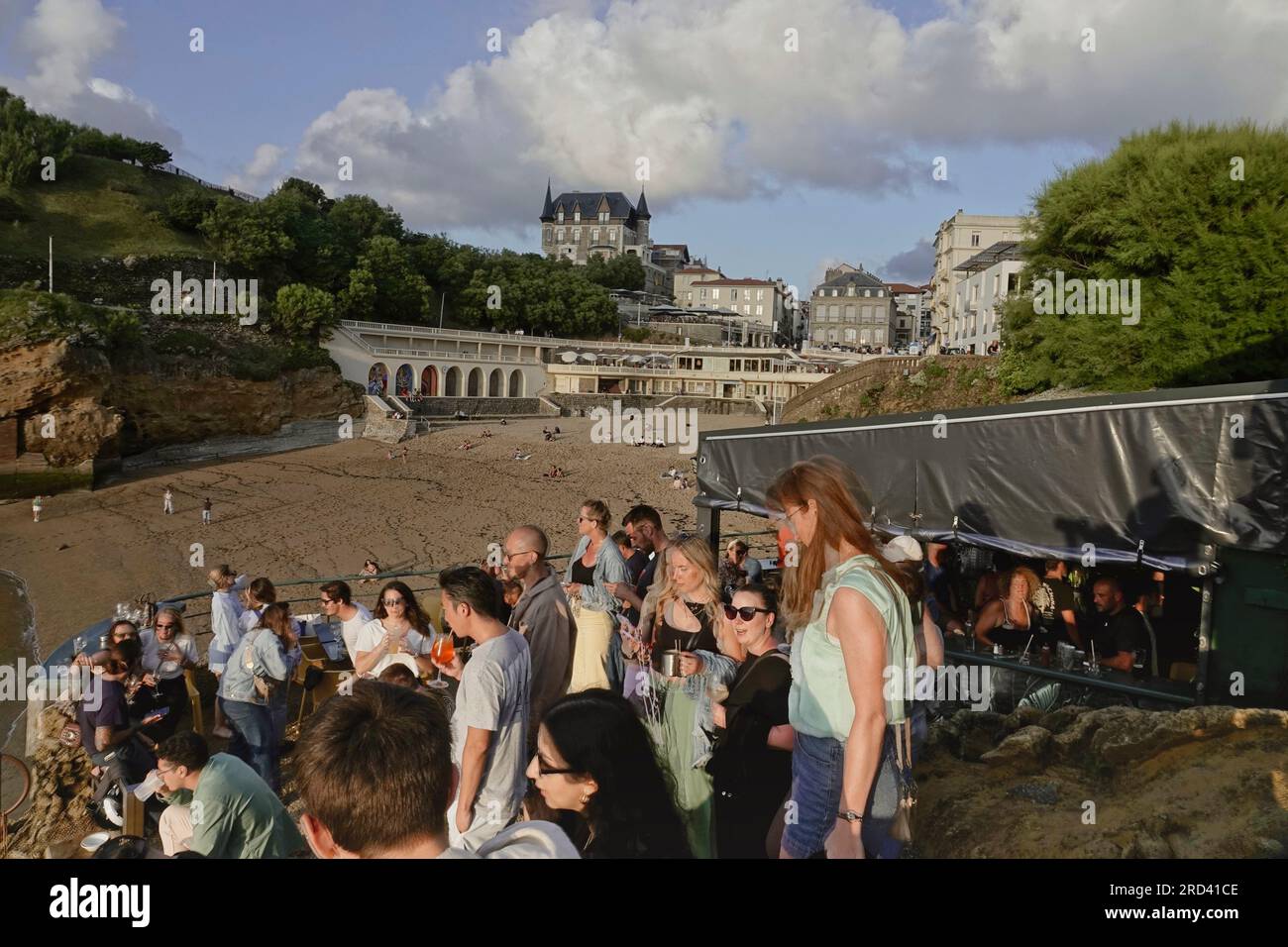 Biarritz, France, July, 2023 As the sun goes down revellers meet at the ...