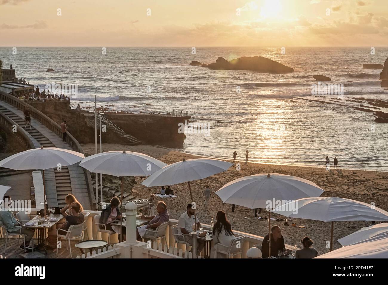 Biarritz, France, July, 2023 As the sun goes down revellers meet at the ...