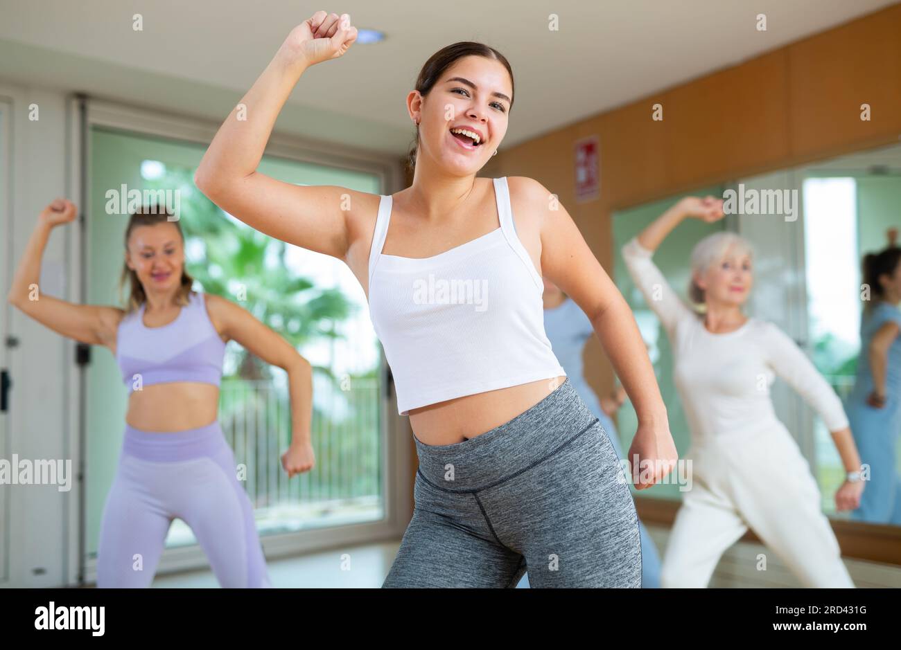 Positive people practicing vigorous lindy hop movements in dance class ...
