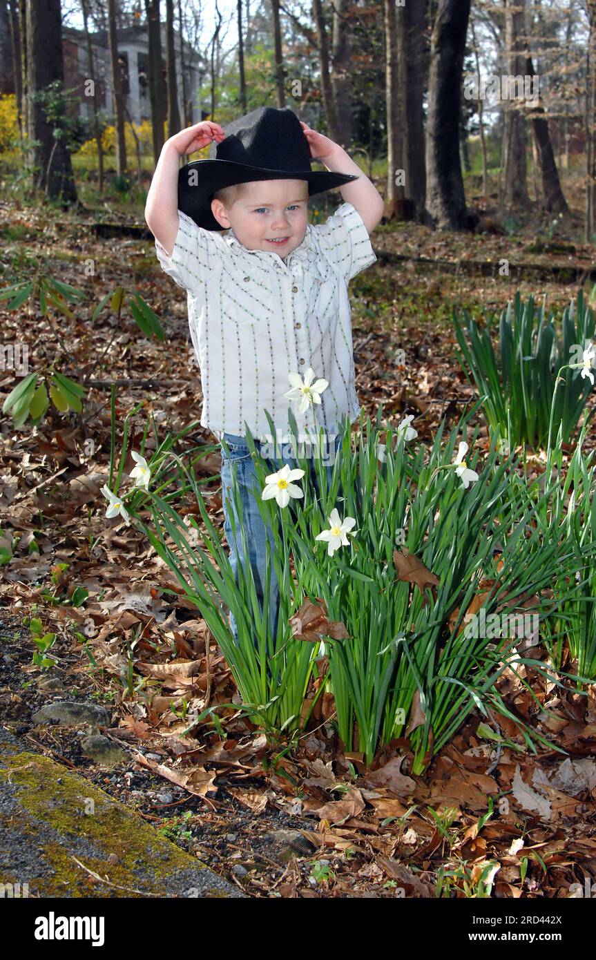 Little boy models his new cowboy hat. The hat is black and his shirt is ...