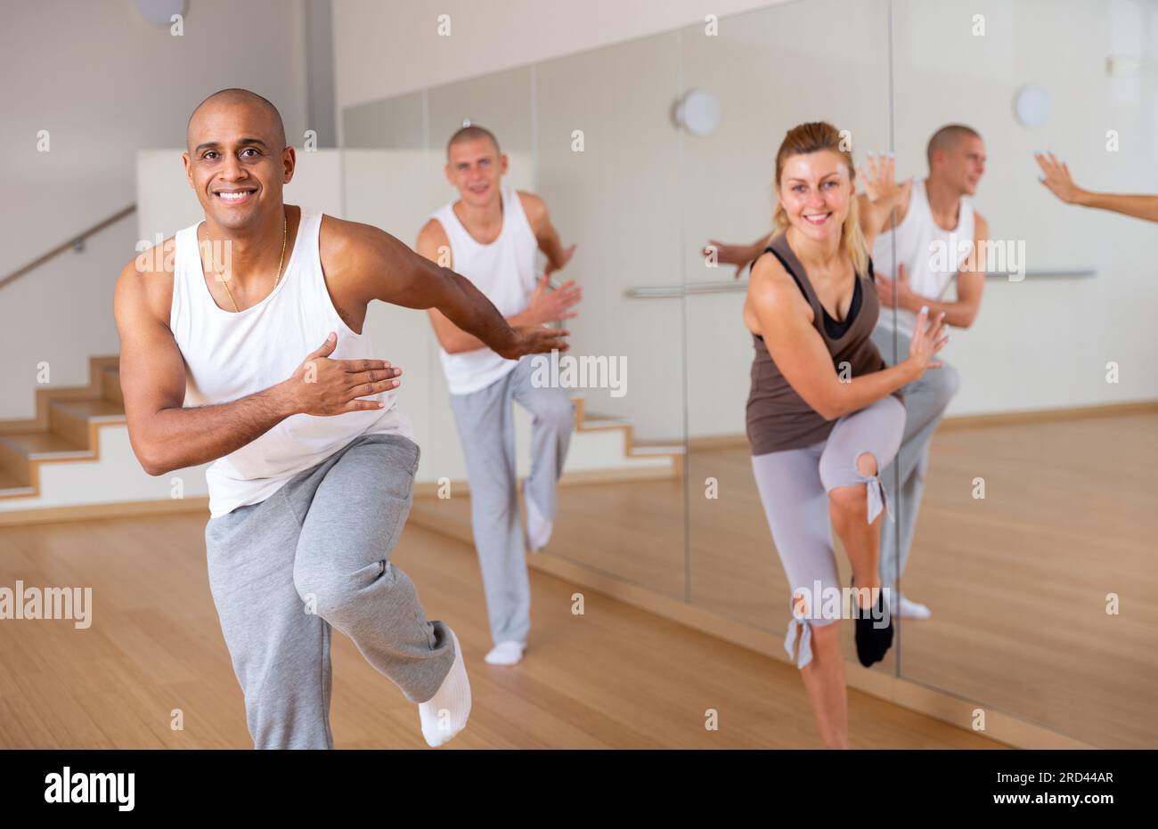Hispanic man with group enjoying active dance in studio Stock Photo - Alamy