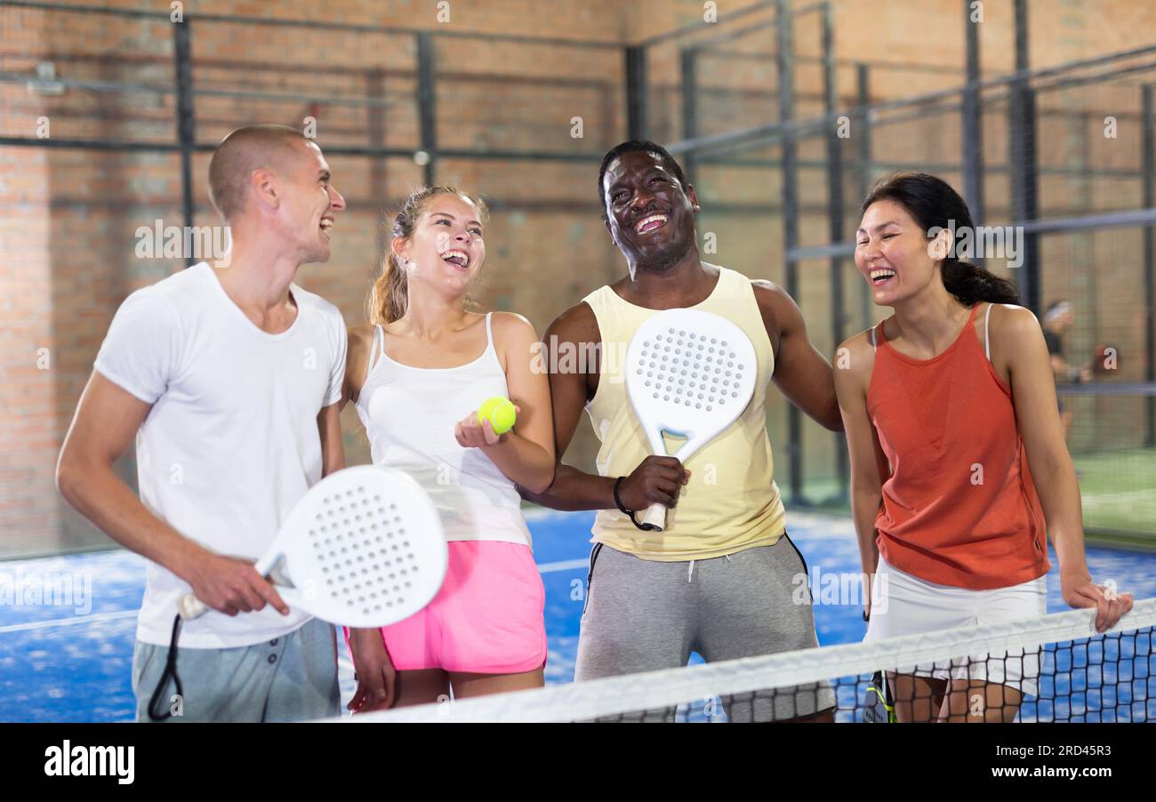 Two happy couples after playing padel on tennis court Stock Photo - Alamy