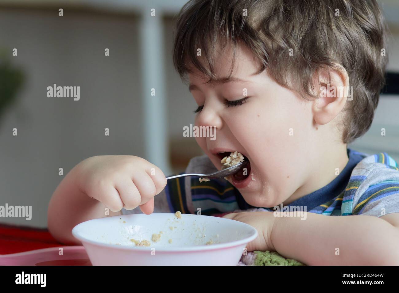 close up of a young boy eating oatmeal for breakfast Stock Photo - Alamy