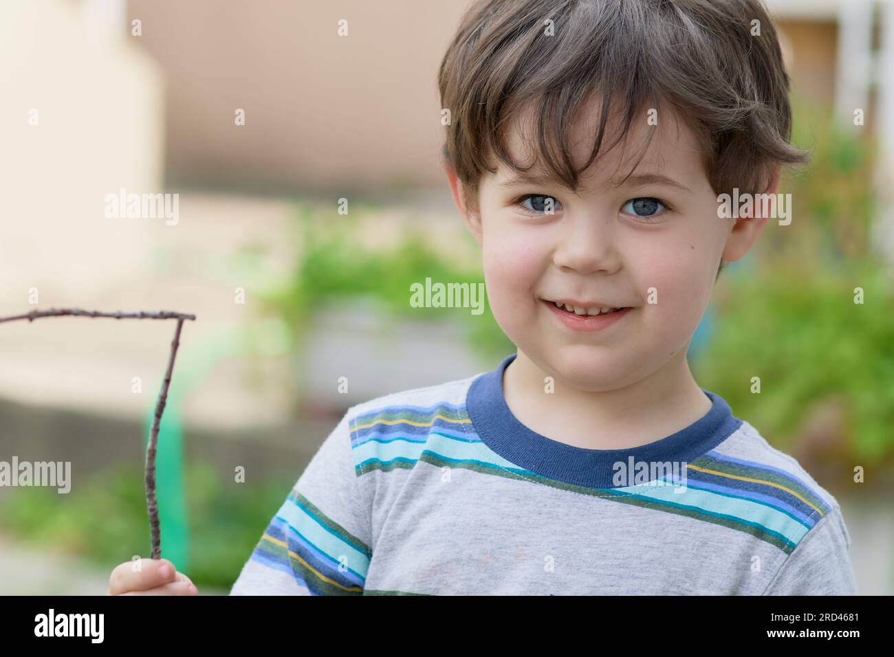 Cute baby boy playing with a stick in the backyard Stock Photo - Alamy