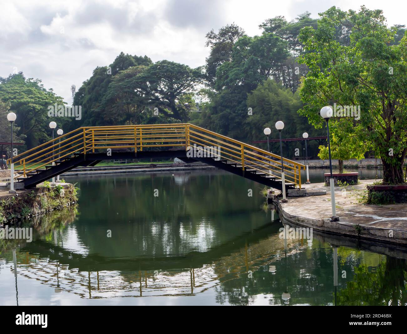 Scenic view of a pond and yellow bridge in the city park of Yogyakarta ...