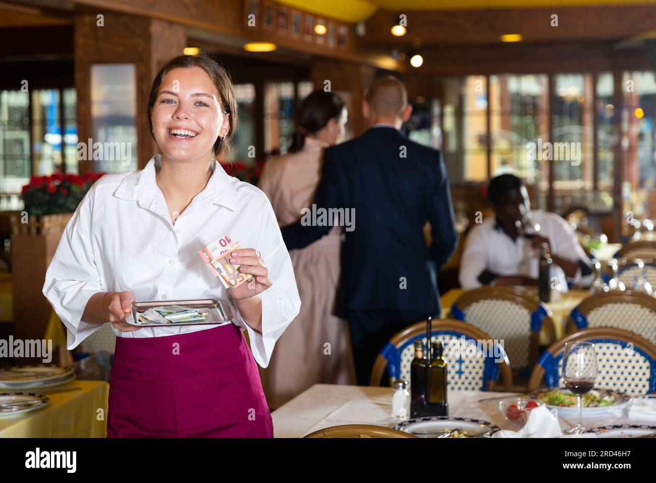 Happy woman waiter with good tip in restaurant Stock Photo - Alamy