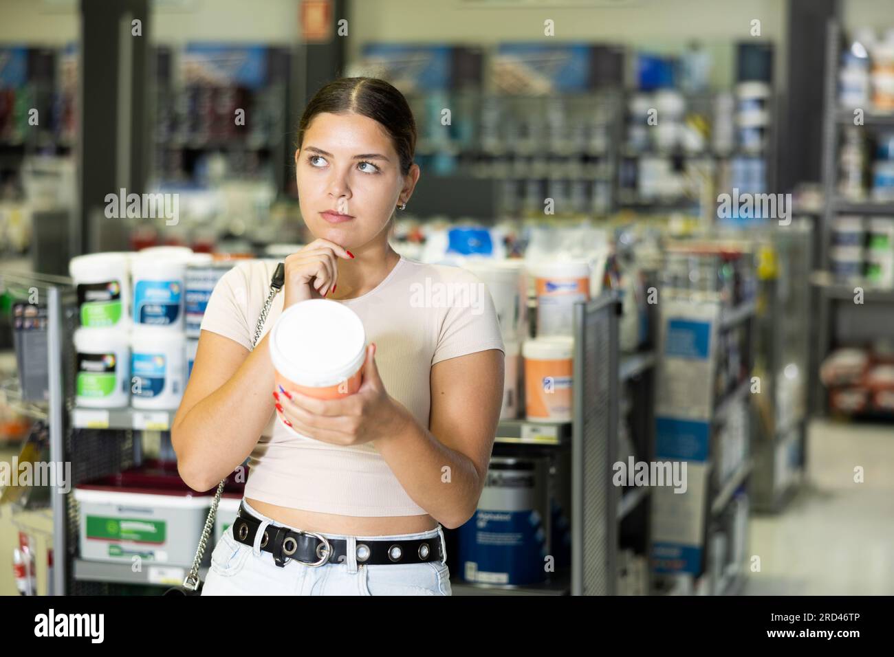 Thoughtful young girl choosing paint in hardware store Stock Photo - Alamy