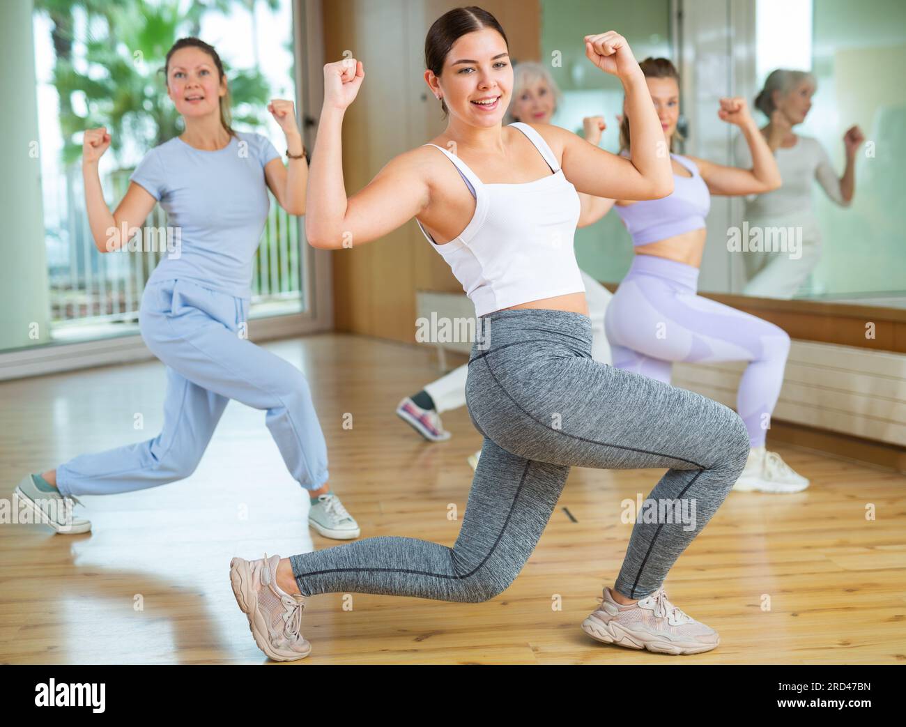 Positive people practicing vigorous lindy hop movements in dance class ...