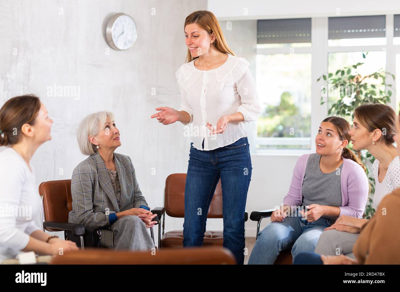 In classroom,girl stands next to colleagues and tells audience her ...