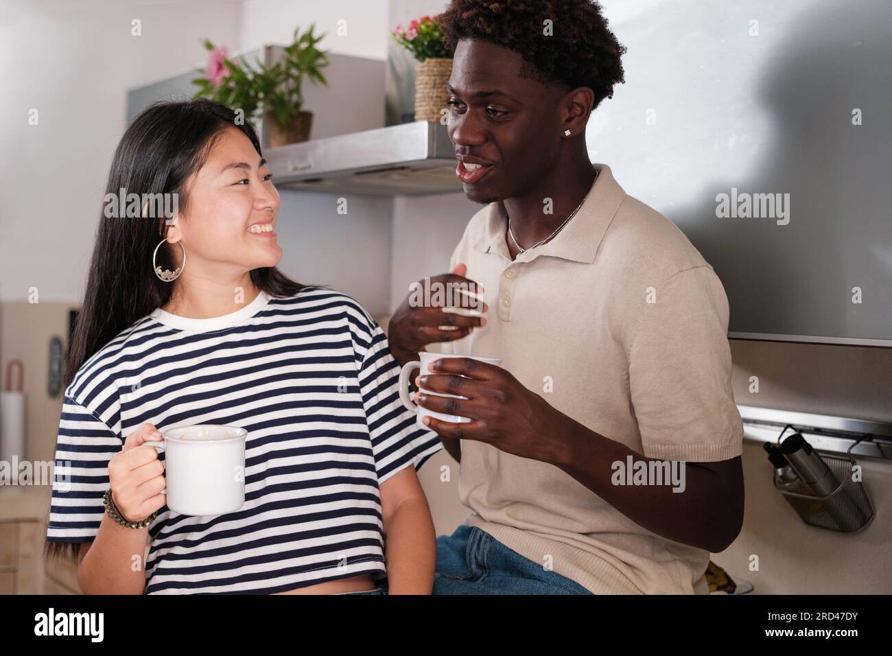 Young multiracial couple taking a break hugging and talking in the ...