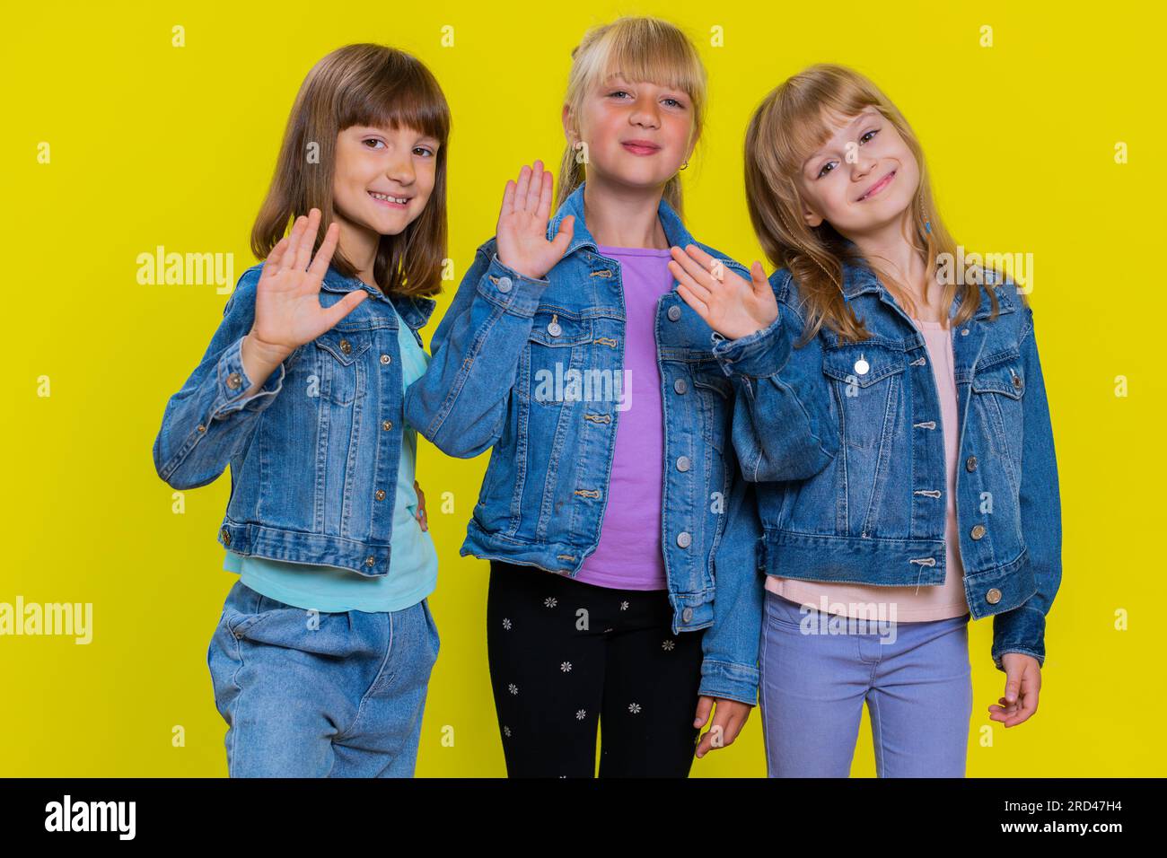 Teenage girls smiling friendly at camera and waving hands gesturing ...