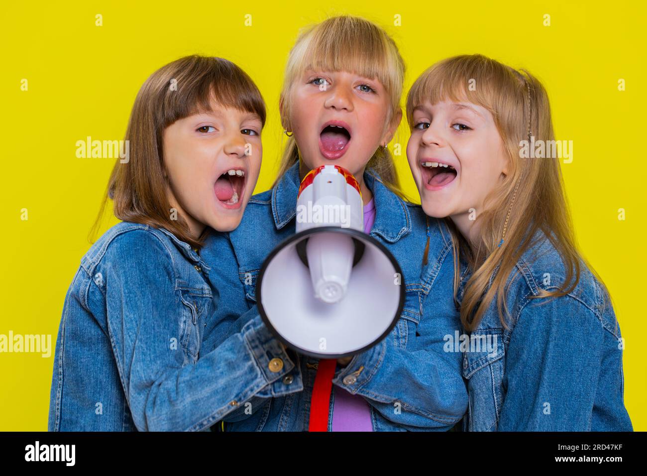 Teenage girls talking with megaphone, proclaiming news, loudly ...