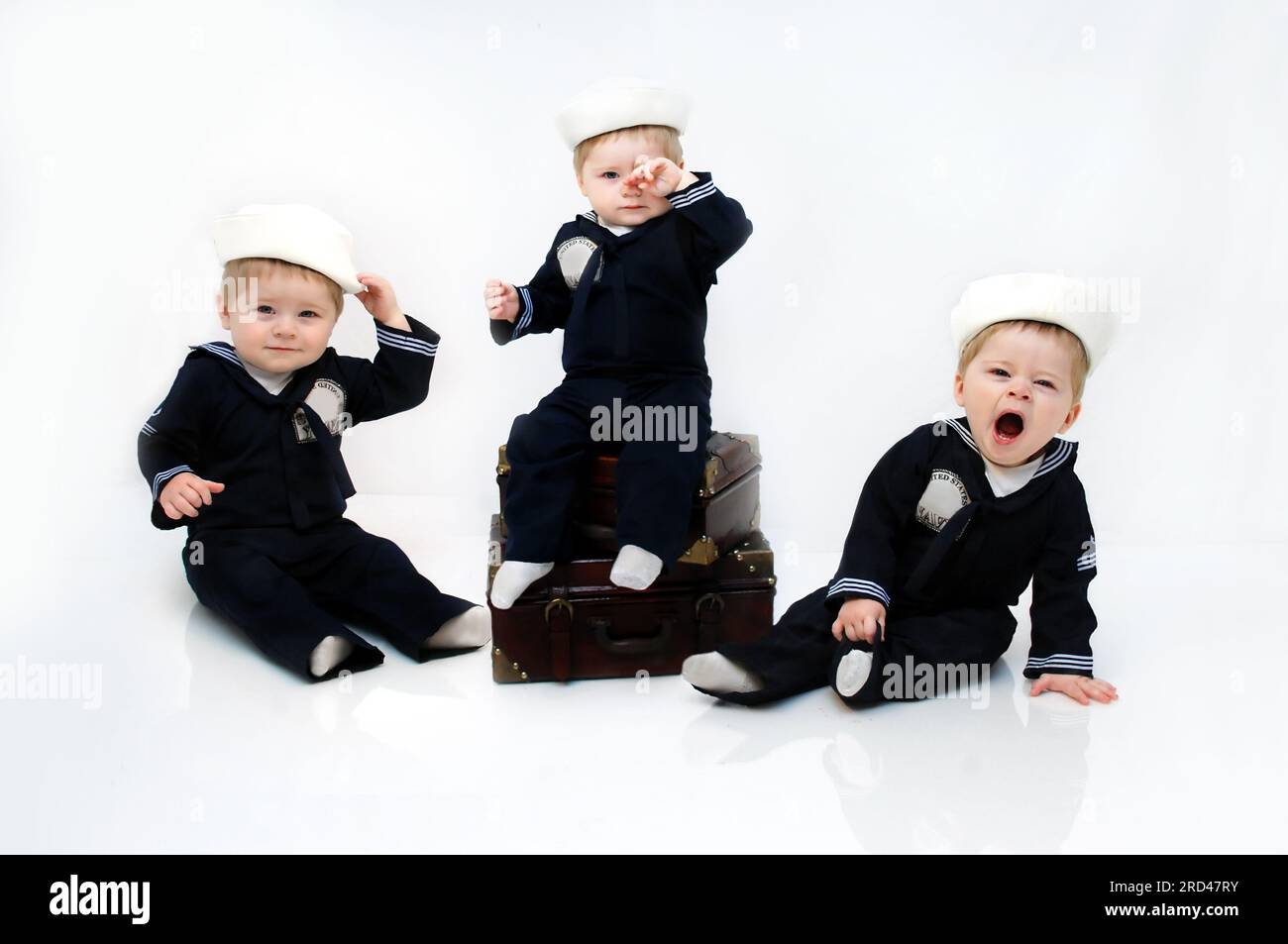 Adorable baby boy wears a navy serviceman costume. He is yawning and ...
