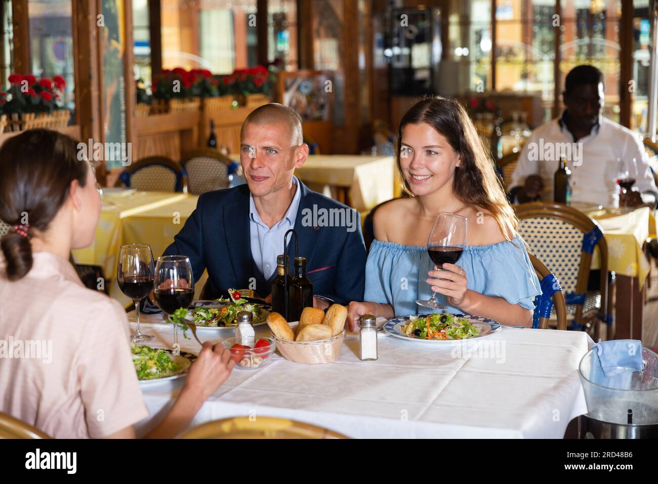 Company of smiling friends having dinner in restaurant Stock Photo - Alamy