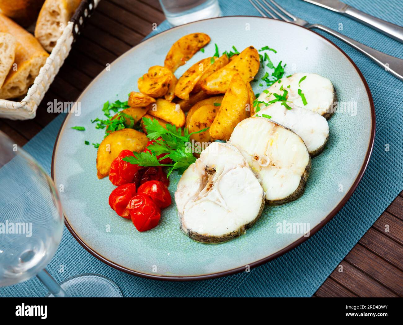 Hake fish with parsley, pickled tomatoes and potatoes Stock Photo - Alamy