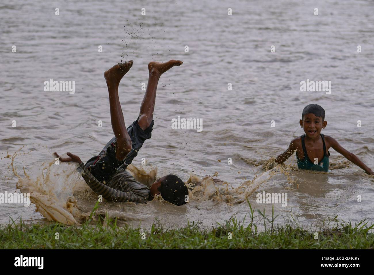 Kids play in a muddy field as the fields are filled with monsoon rains ...
