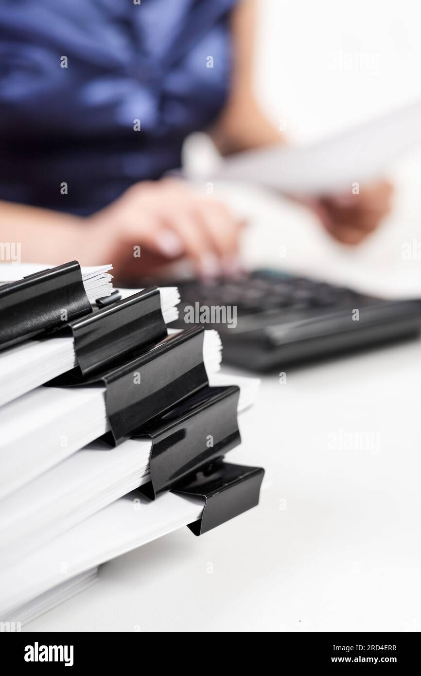 A stack of papers with Binder Clips against the background of an office ...