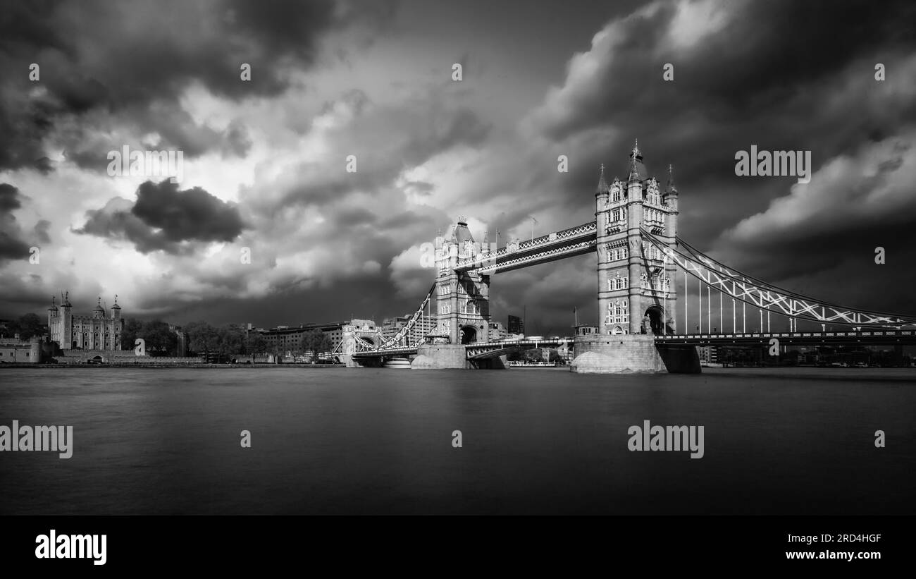 A black and white image of ominous clouds over Tower Bridge in London ...