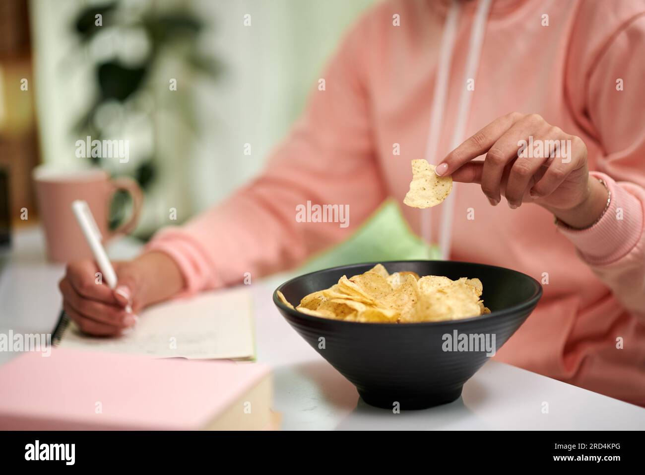 College student eating potato chips when doing homework Stock Photo - Alamy