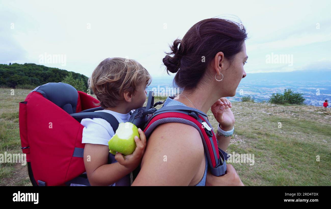 Parent and toddler boy hiking in outdoors mother carrying child in ...
