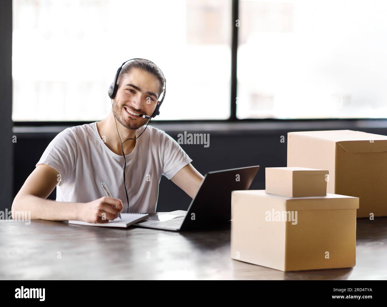 Happy Manager Guy With Headset Taking Notes At Laptop Indoor Stock ...