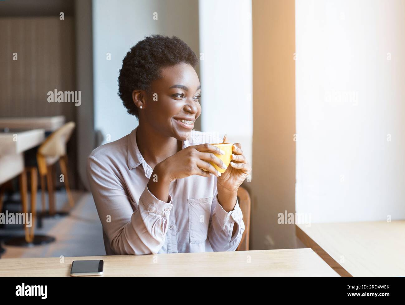 Millennial African lady relaxing with cup of coffee in cafe Stock Photo ...