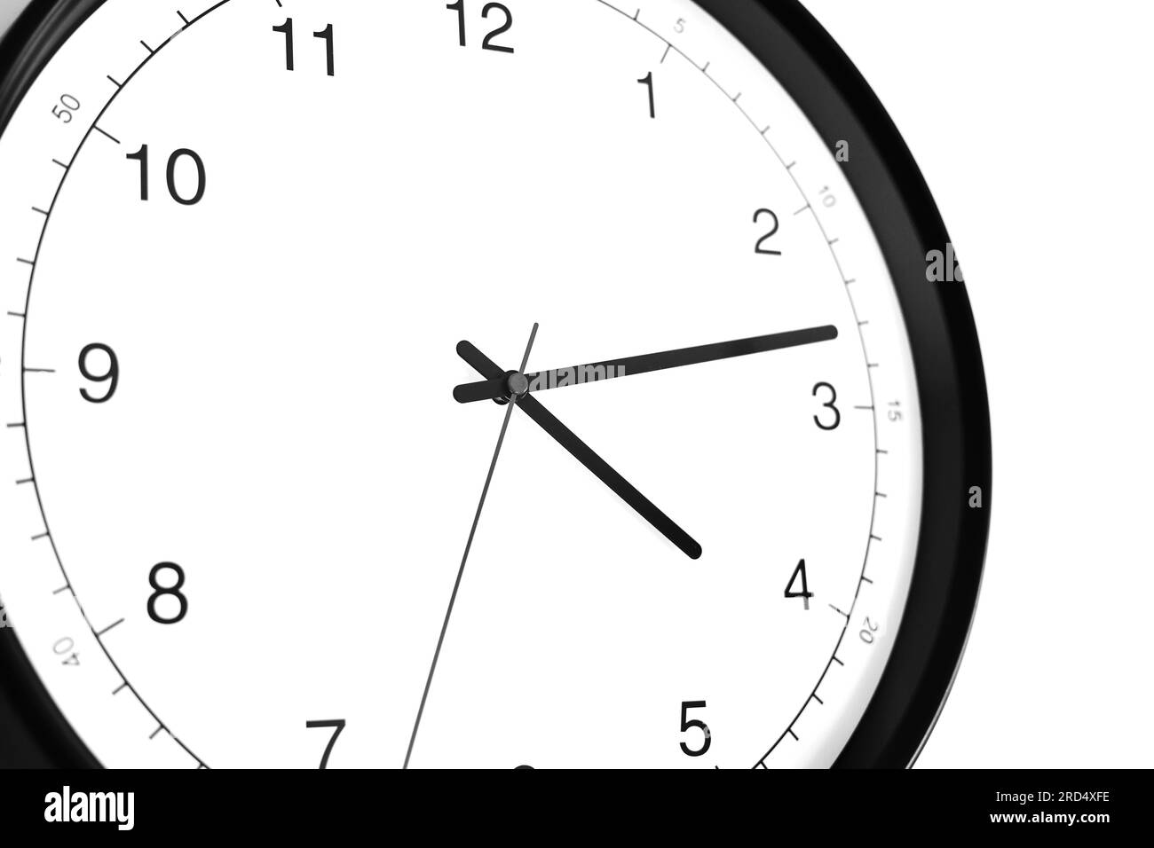 Part of analogue plain wall clock on white wall background. Four o ...